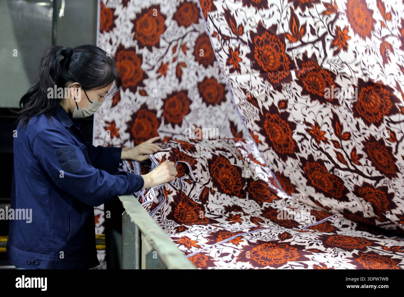 A woman works in a textile factory producing African wax prints in ...