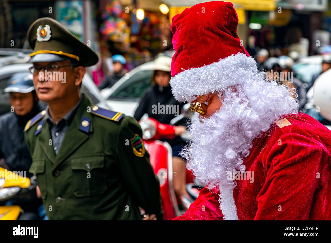 Father Christmas dummy in front of Vietnamese Naval officer in busy ...