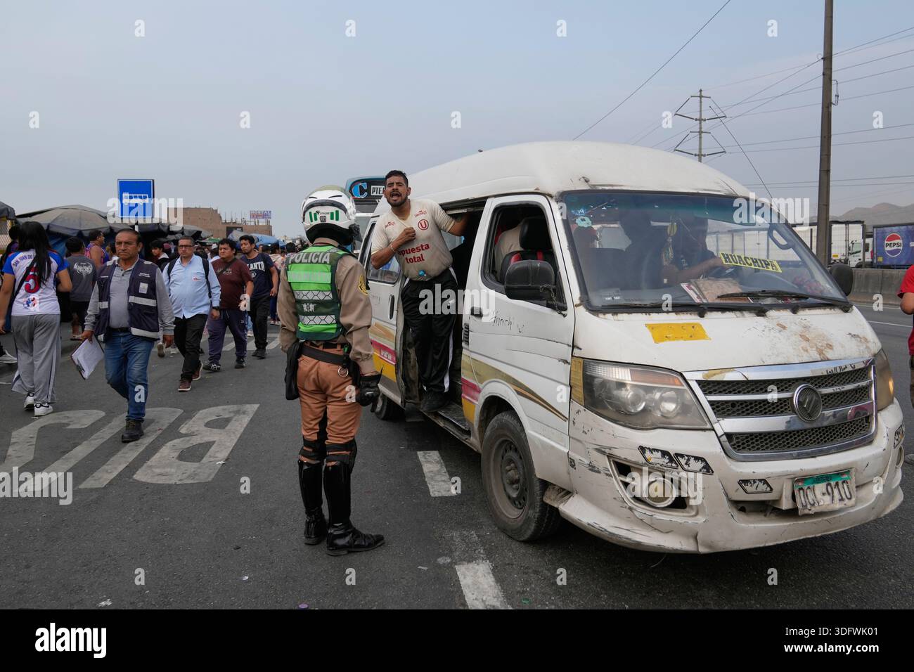 A man in a collective van shouts out the route where commuters board ...