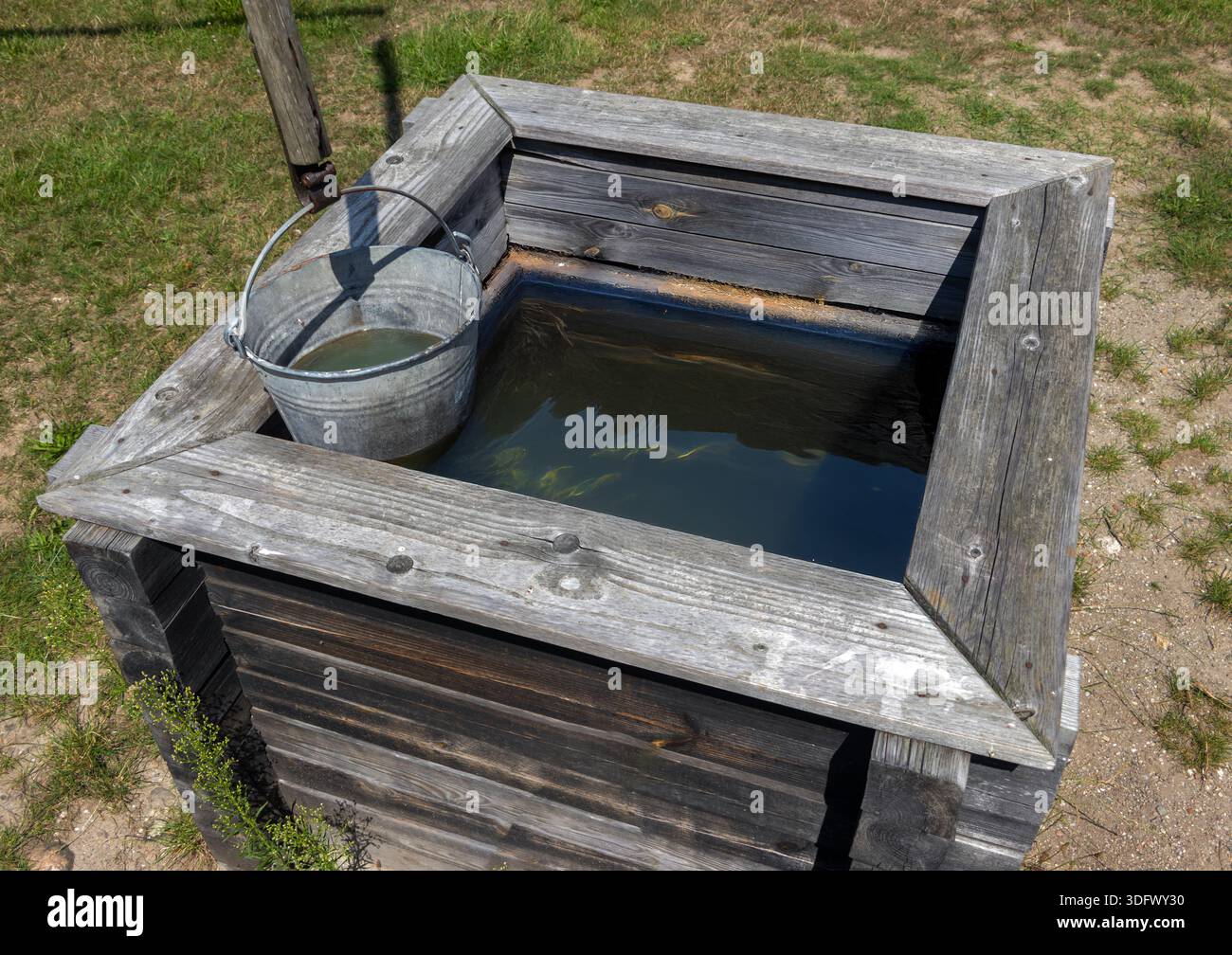Old wooden well with a bucket full of fresh water on a pulley Stock ...