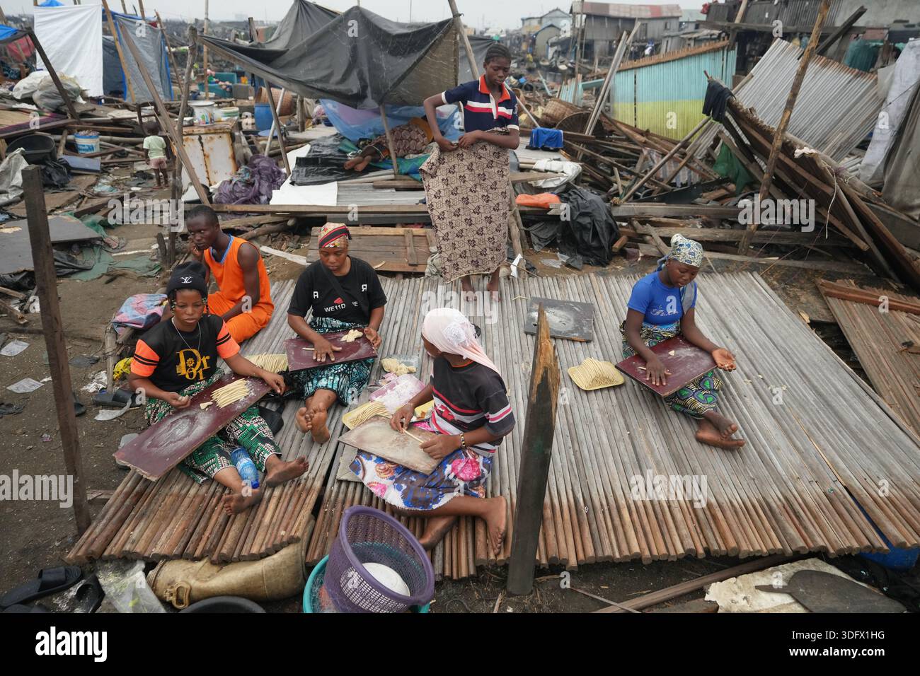 Women prepare snacks at the ruins of their demolished stilts house by ...