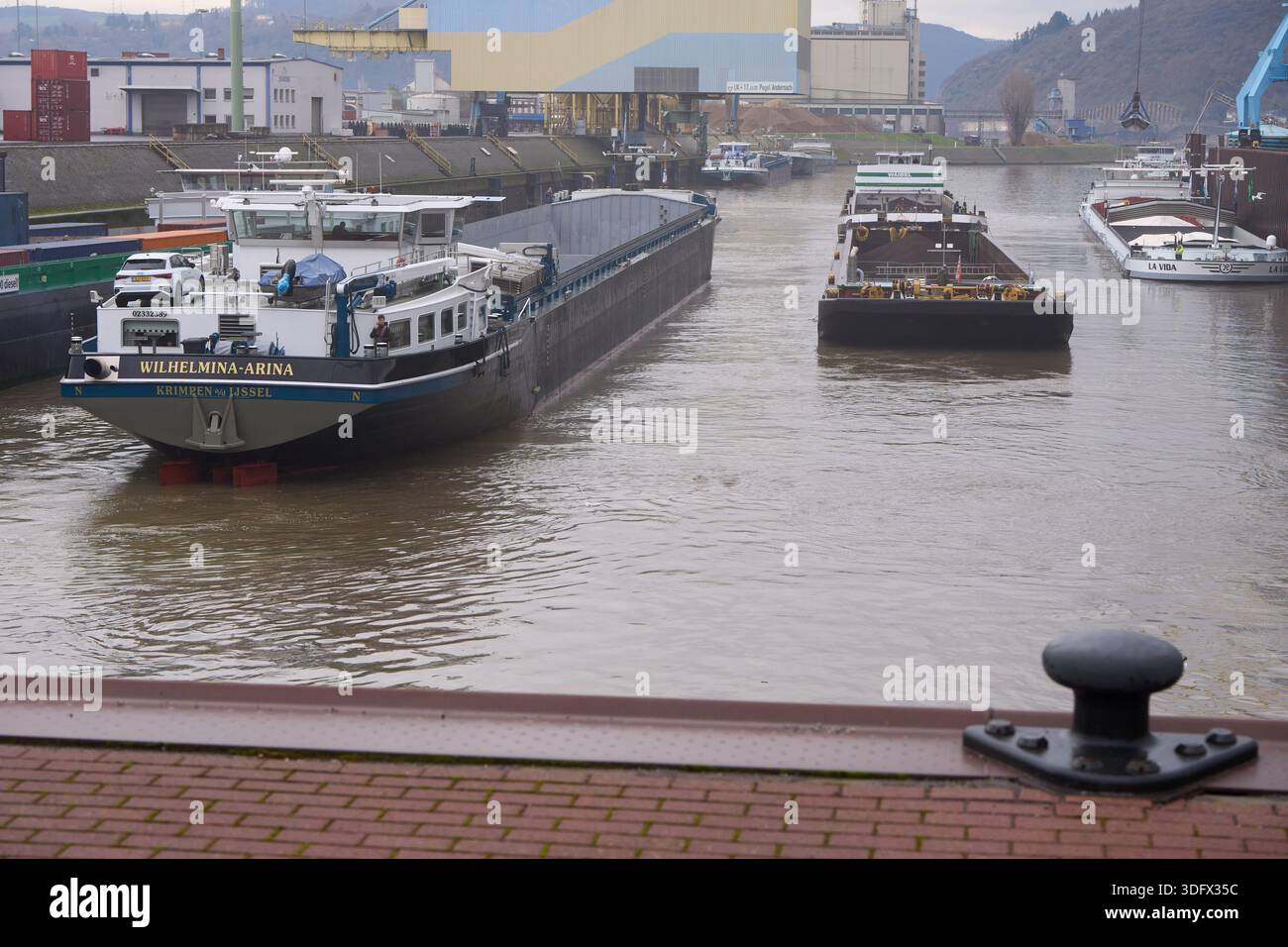 14 January 2026, Rhineland-Palatinate, Andernach: Cargo ships maneuver ...