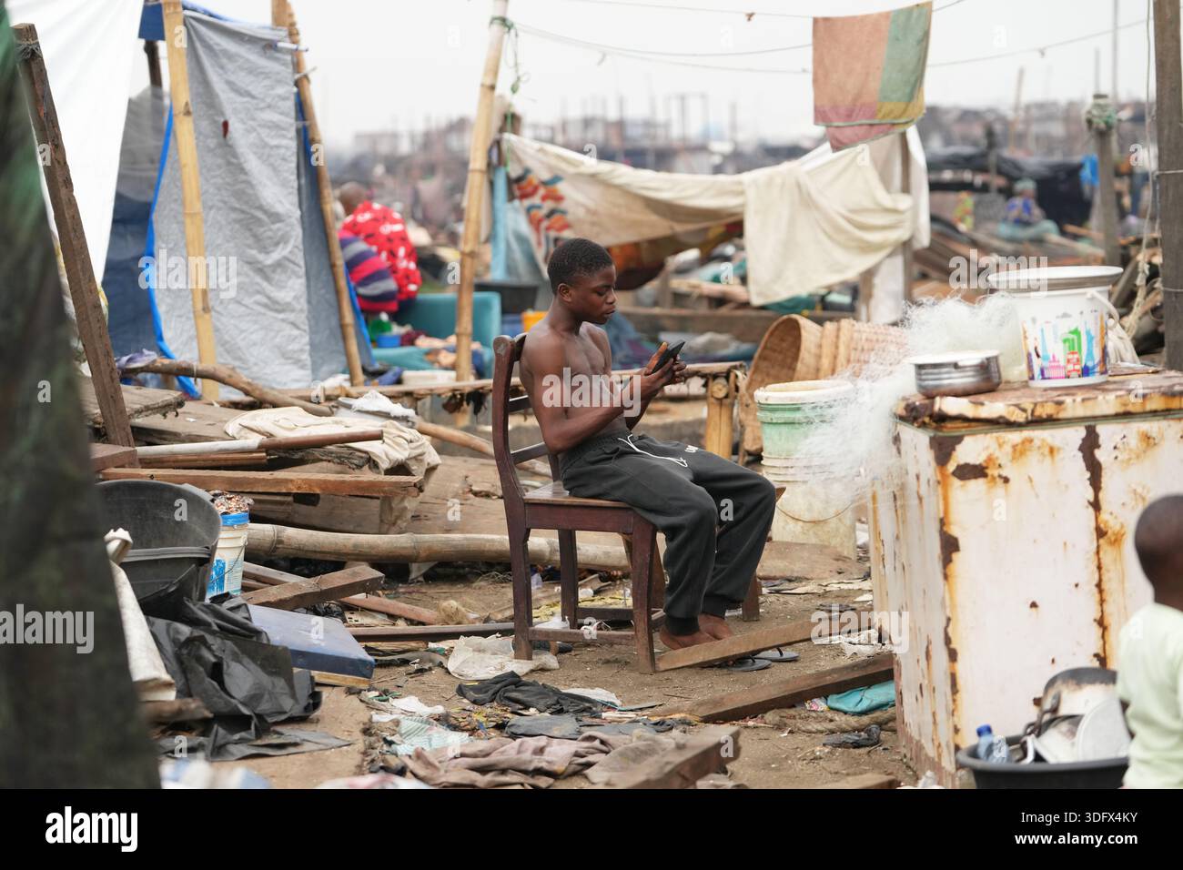 A boy sits at the ruins of his demolished stilts house by authorities ...