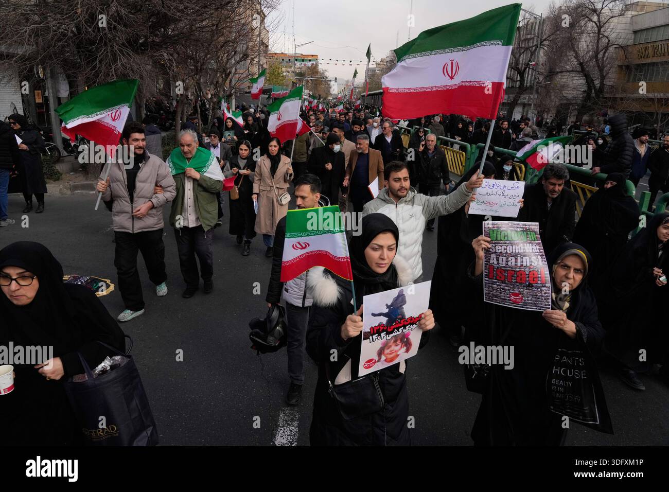 People carry Iranian flags and pro-government placards during a funeral ...