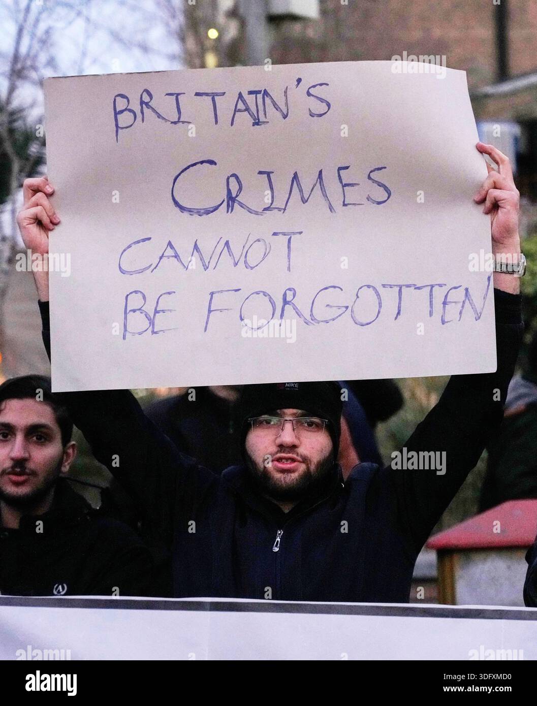 A pro-government Iranian protester holds up an anti-British placard in ...
