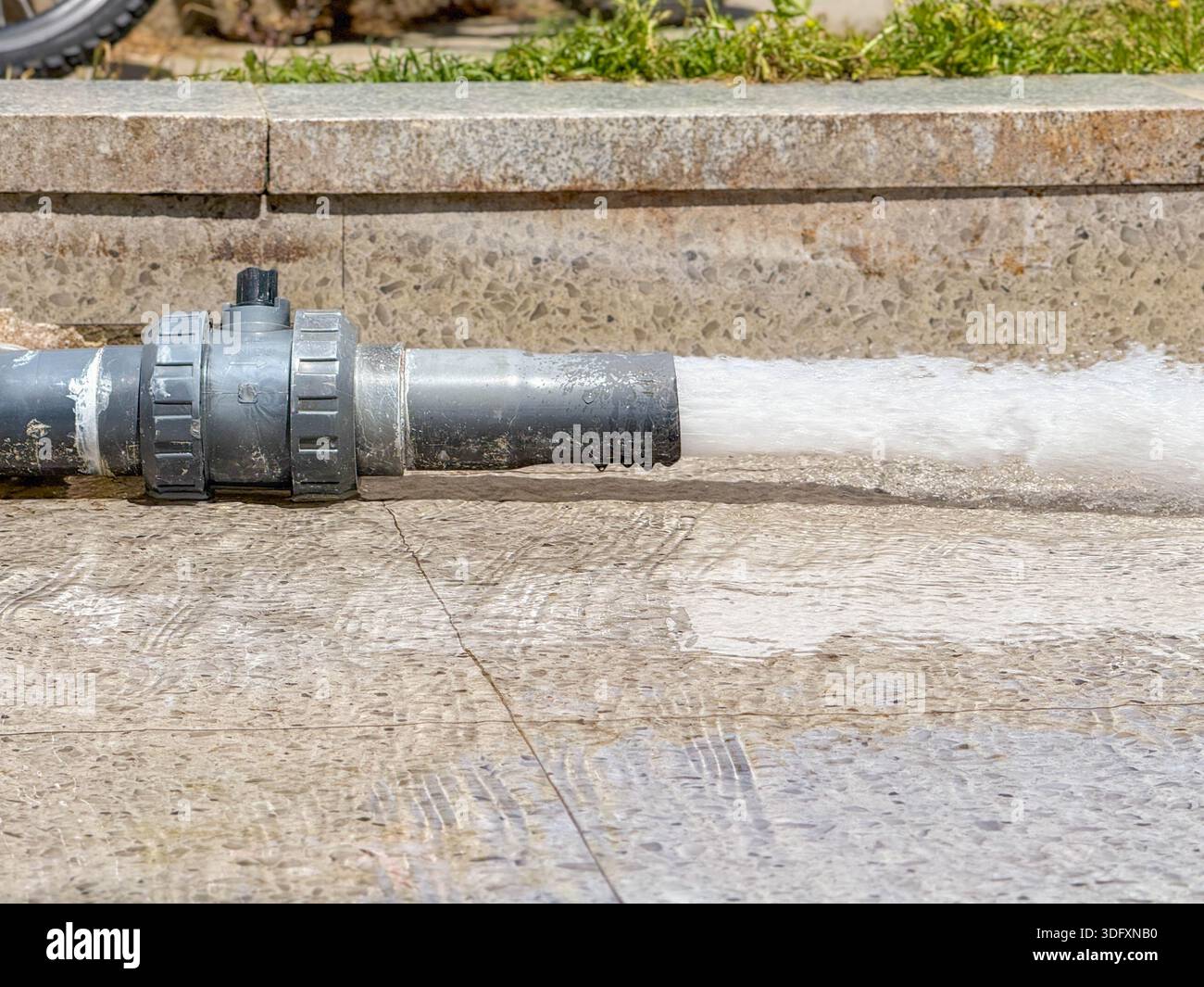 Water gushing from pipe onto pavement during infrastructure work Stock ...