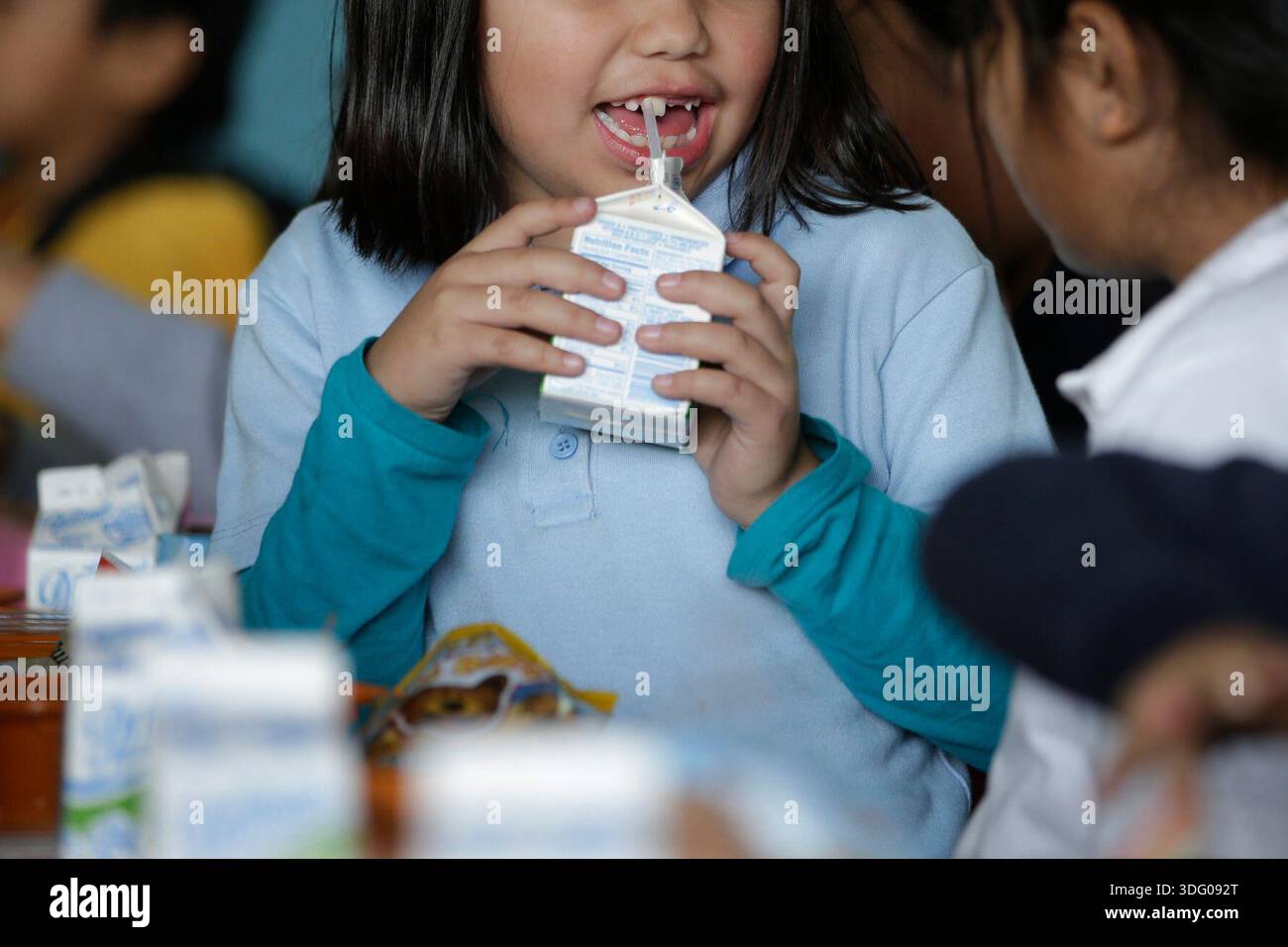 FILE - A student drinks milk in the cafeteria area of an elementary ...