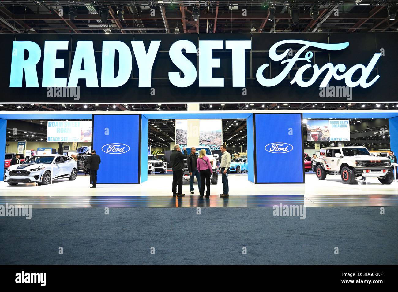 Visitors talk in front of the Ford floor display at the Detroit Auto ...