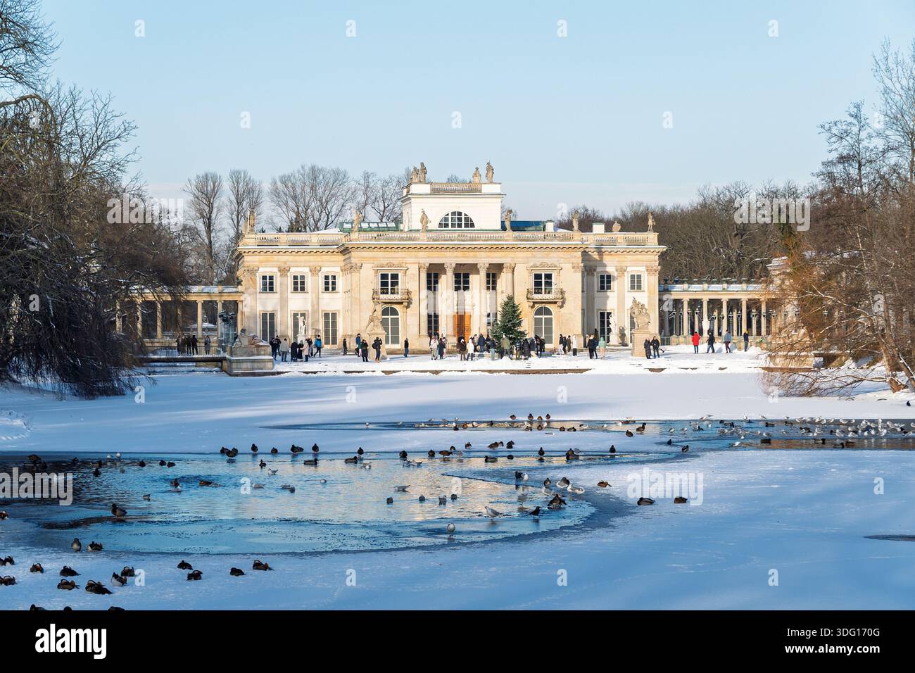 Snowy winter scene at historic palace by frozen lake. Royal Baths Park ...