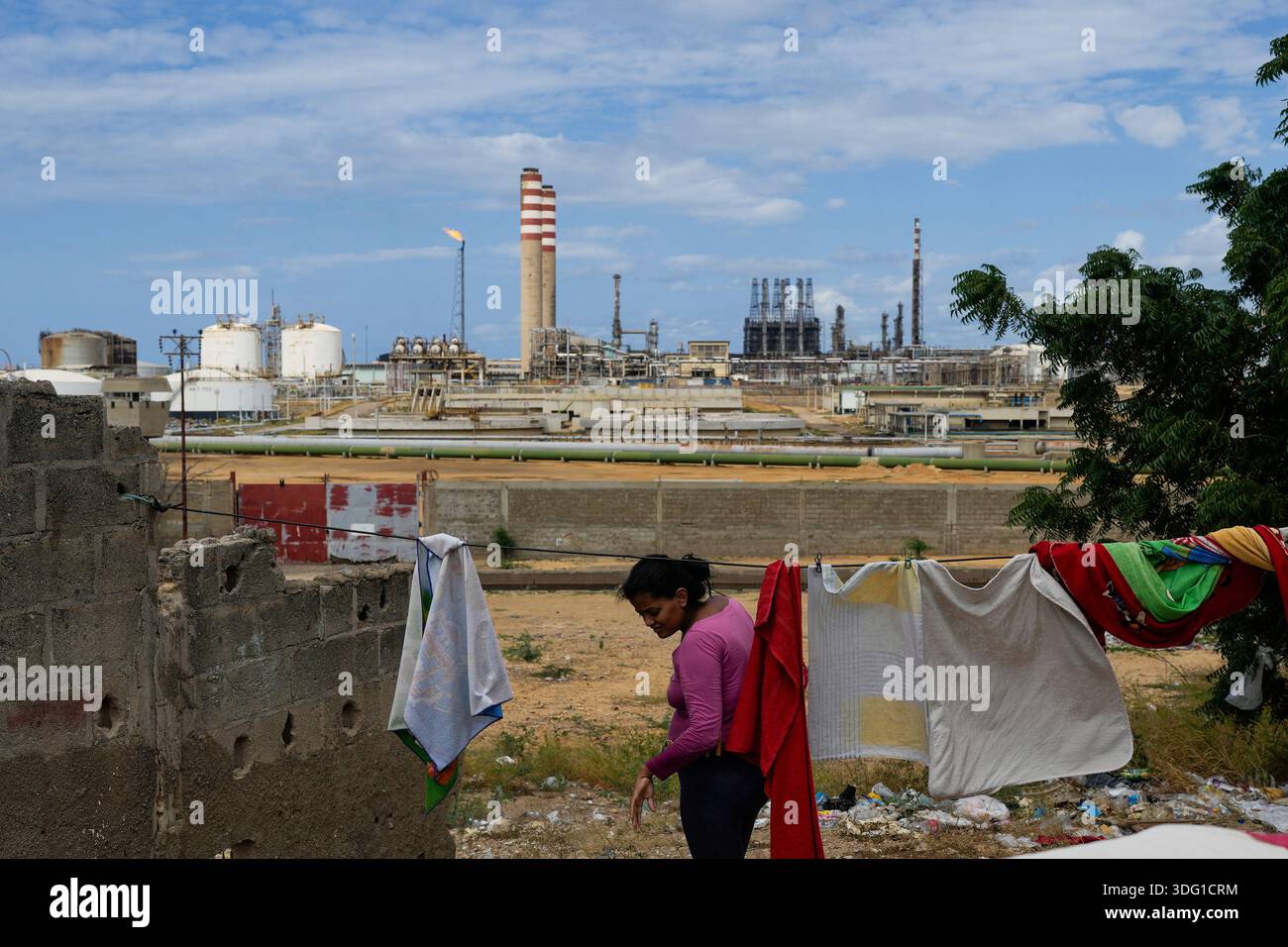 A woman who lives near the Cardon refinery hangs clothes to dry in ...