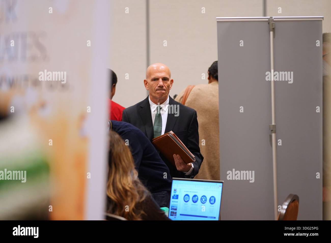 Job seeker Ike Sobel waits to speak to a recruiter during a job fair in ...