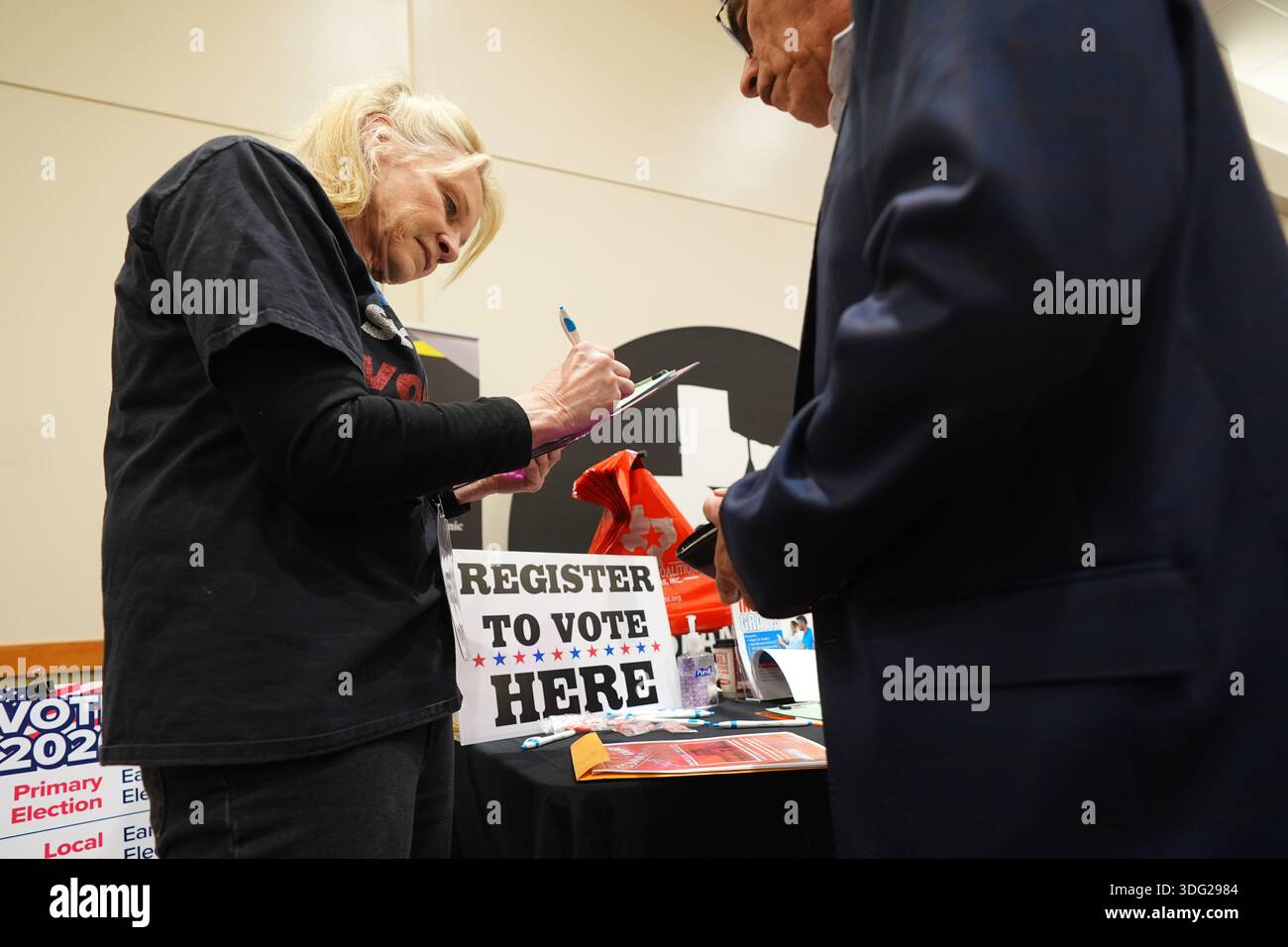 Volunteer Bonnie Moore, left, helps Jamie Ferrera Santos register to ...