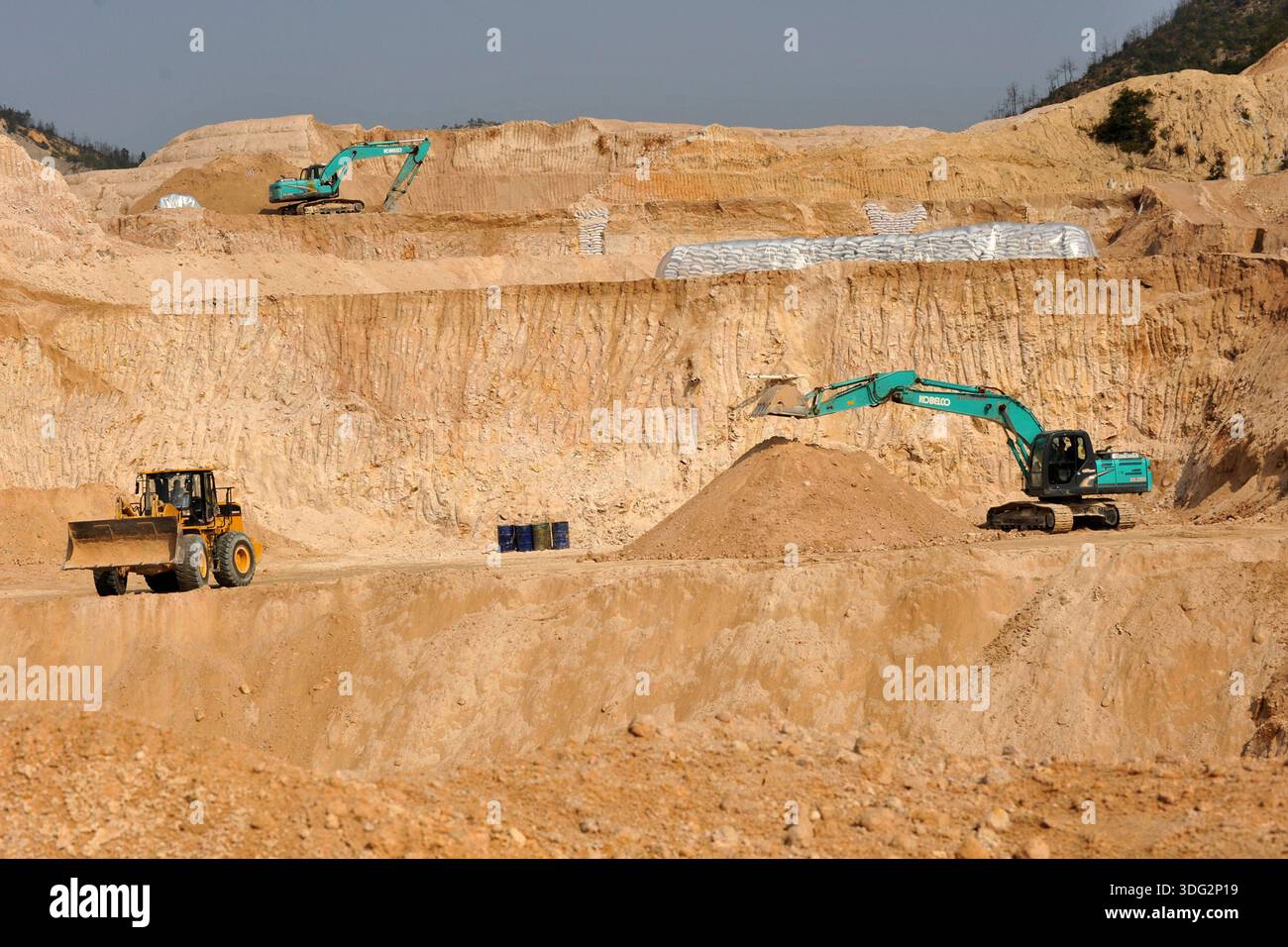 FILE - Workers use machinery to dig at a rare earth mine in Ganxian ...
