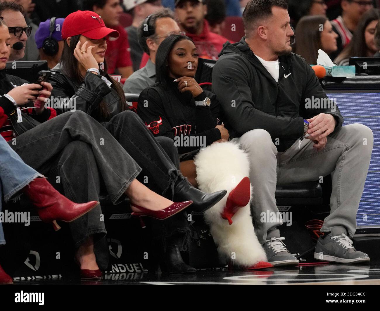 Simone Biles sits courtside during the second half of an NBA basketball ...