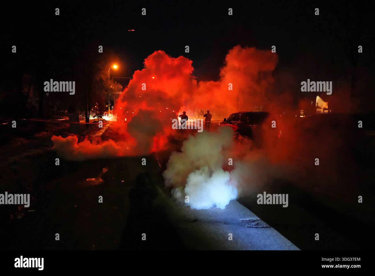Law enforcement officers stand amid tear gas at the scene of a reported ...