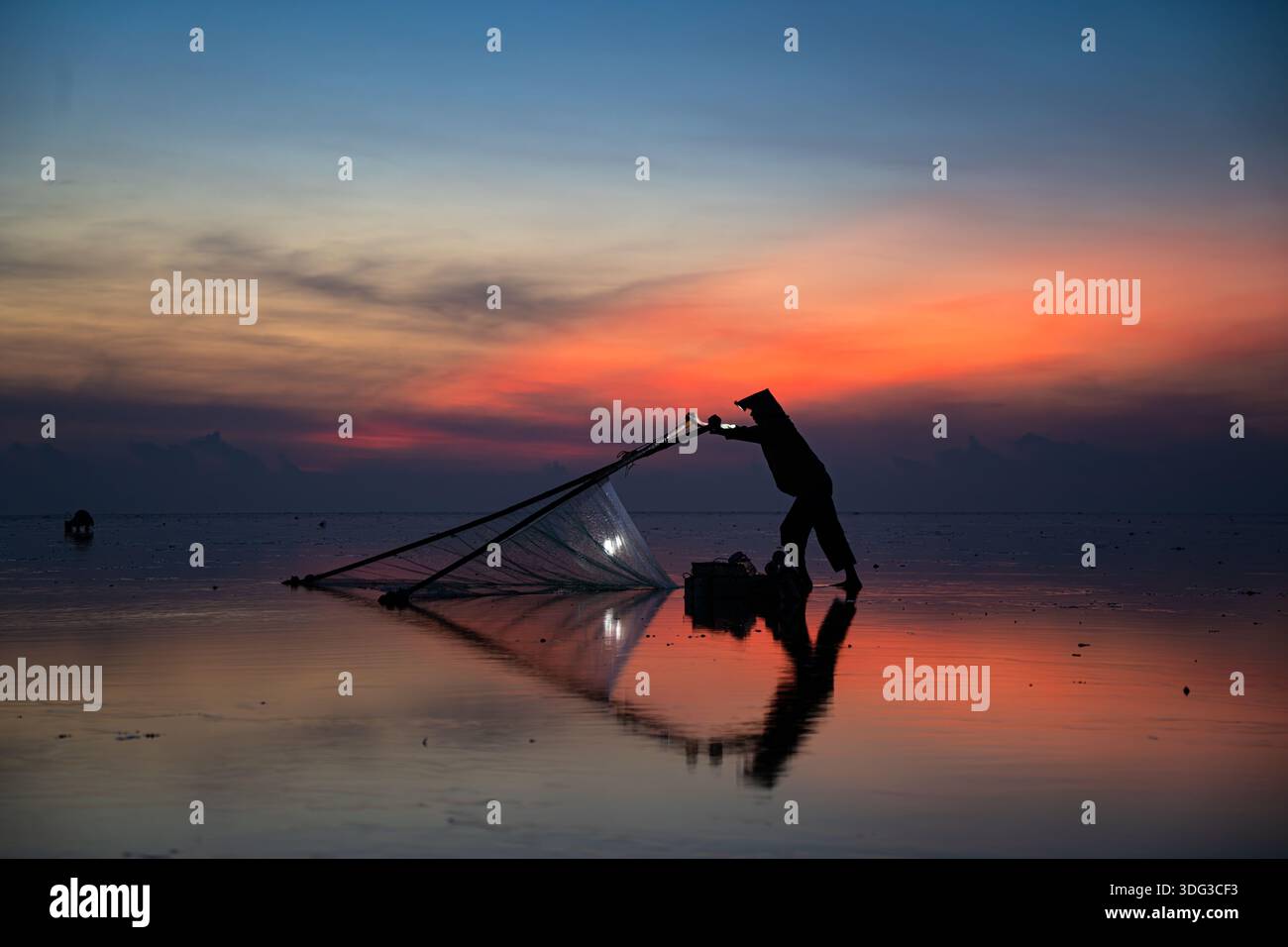 Fishermen at Quang Lang beach, Thai Binh, casting nets at sunrise. A ...