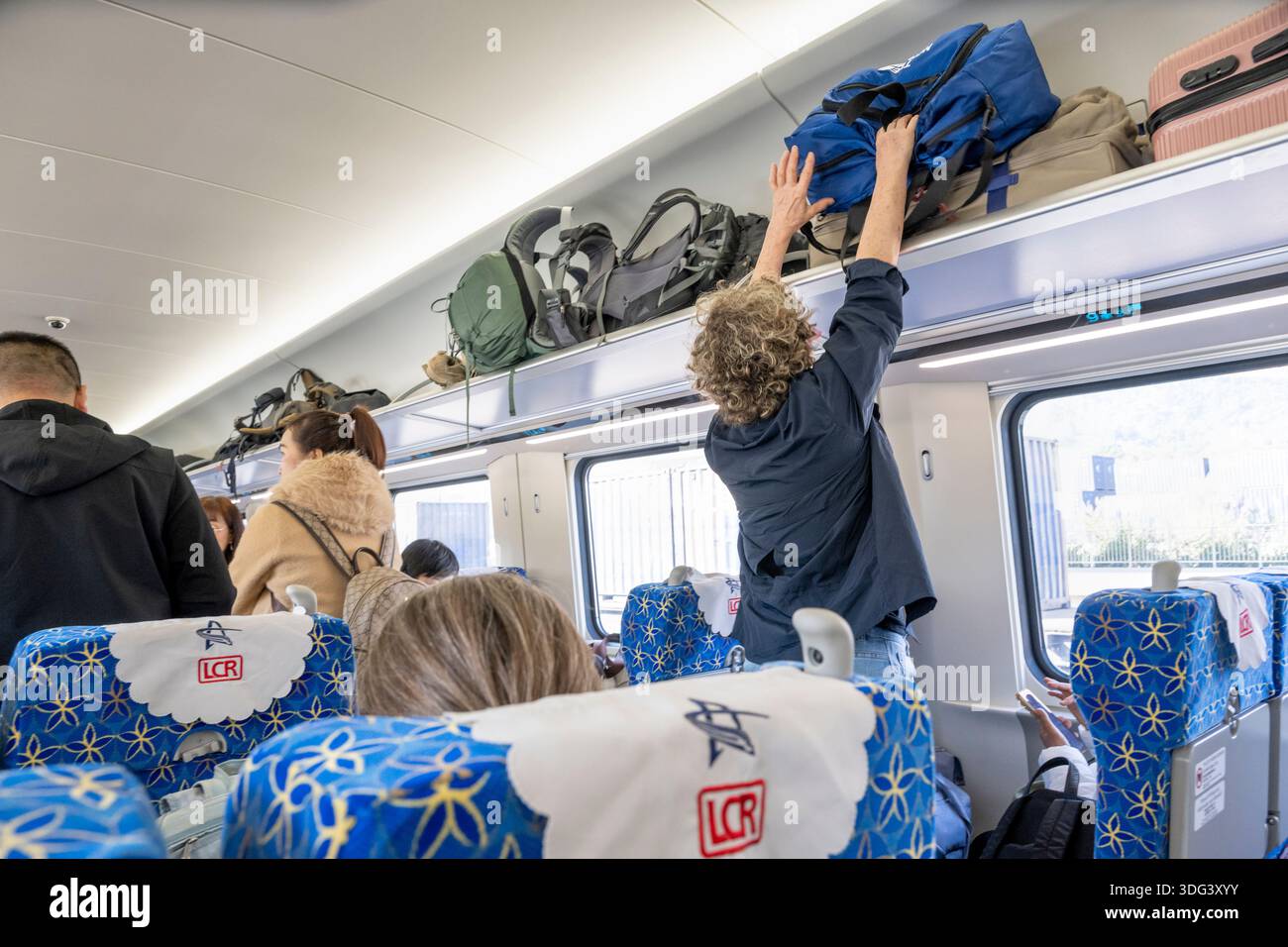 Laos-January 11 2026:Passengers aboard the high speed train sort their ...