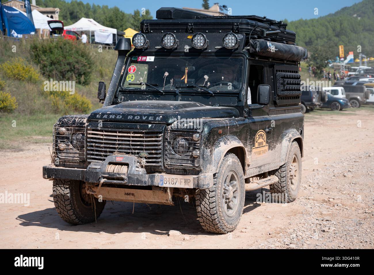 Iconic, fully equipped Land Rover Defender in black, covered in mud ...