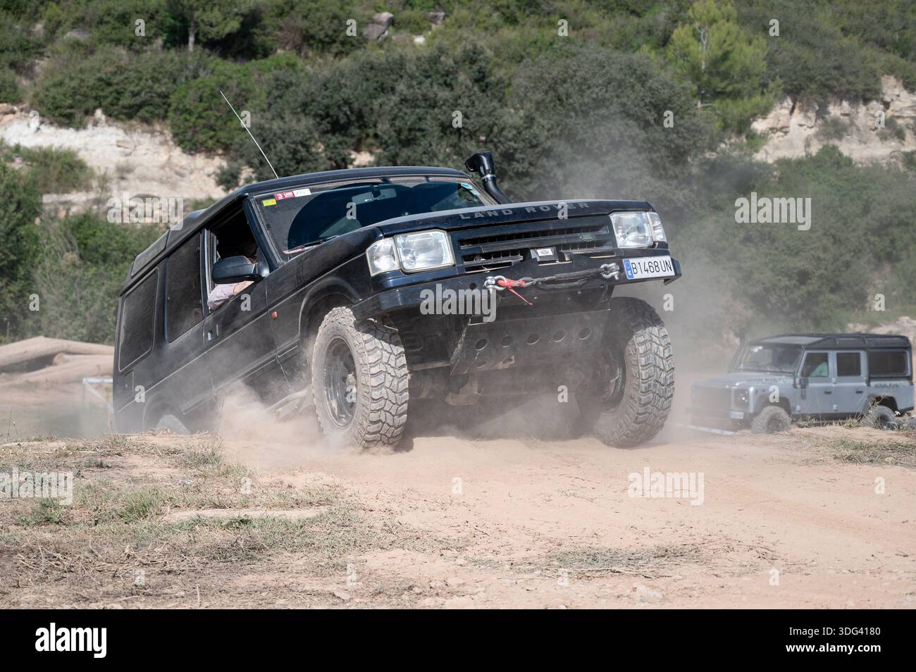 Modified black Land Rover Discovery Series I 4x4 climbing a dusty hill ...