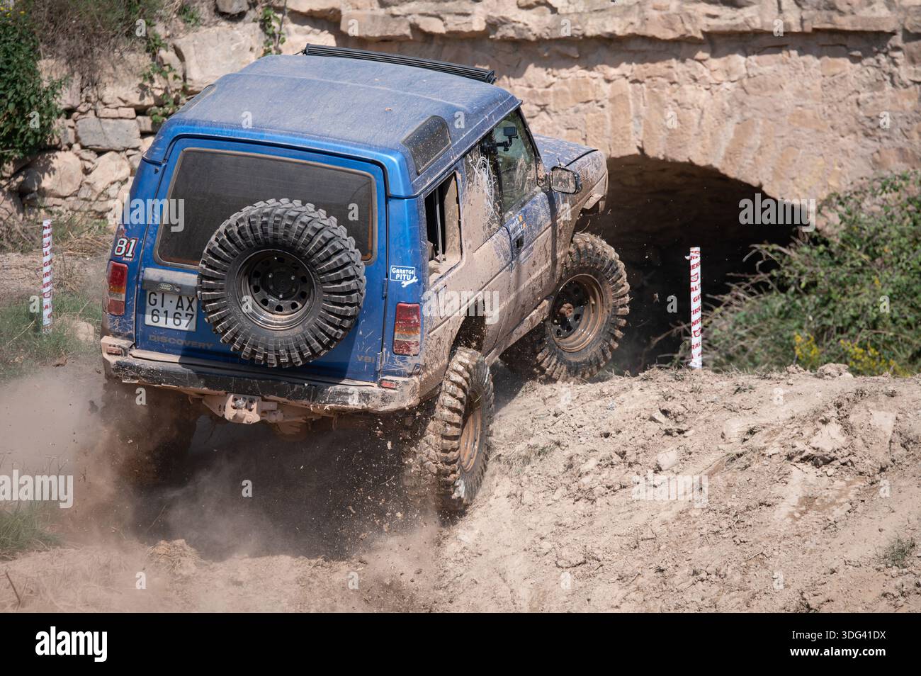 Rear view of a modified blue Land Rover Discovery Series I climbing a ...