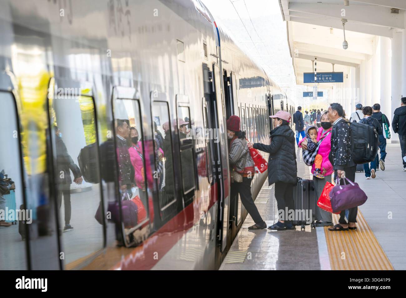 Laos-January 11 2026:Passengers board a high speed modern train,as it ...