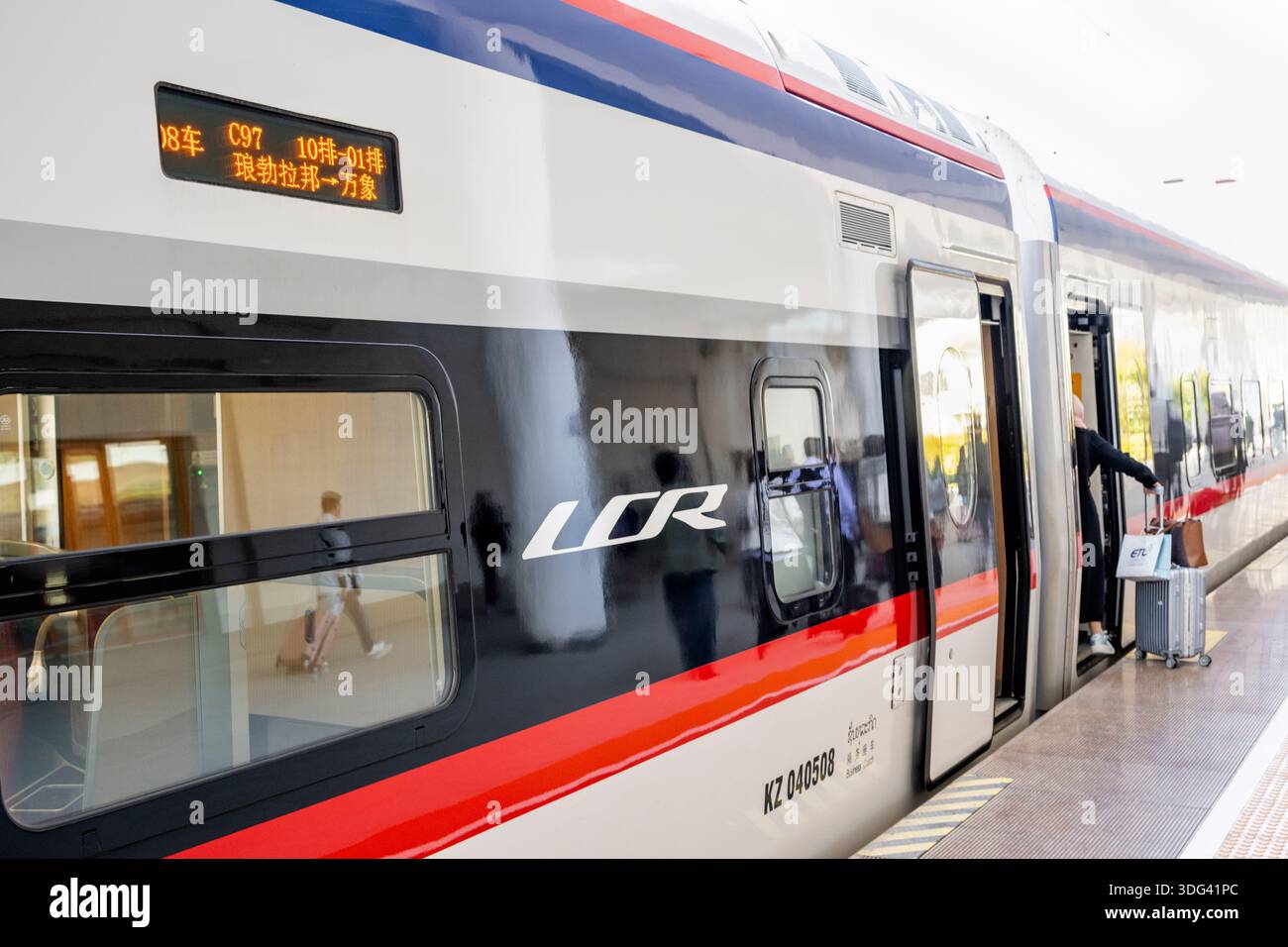 Laos-January 11 2026:Passengers board a high speed modern train,as it ...