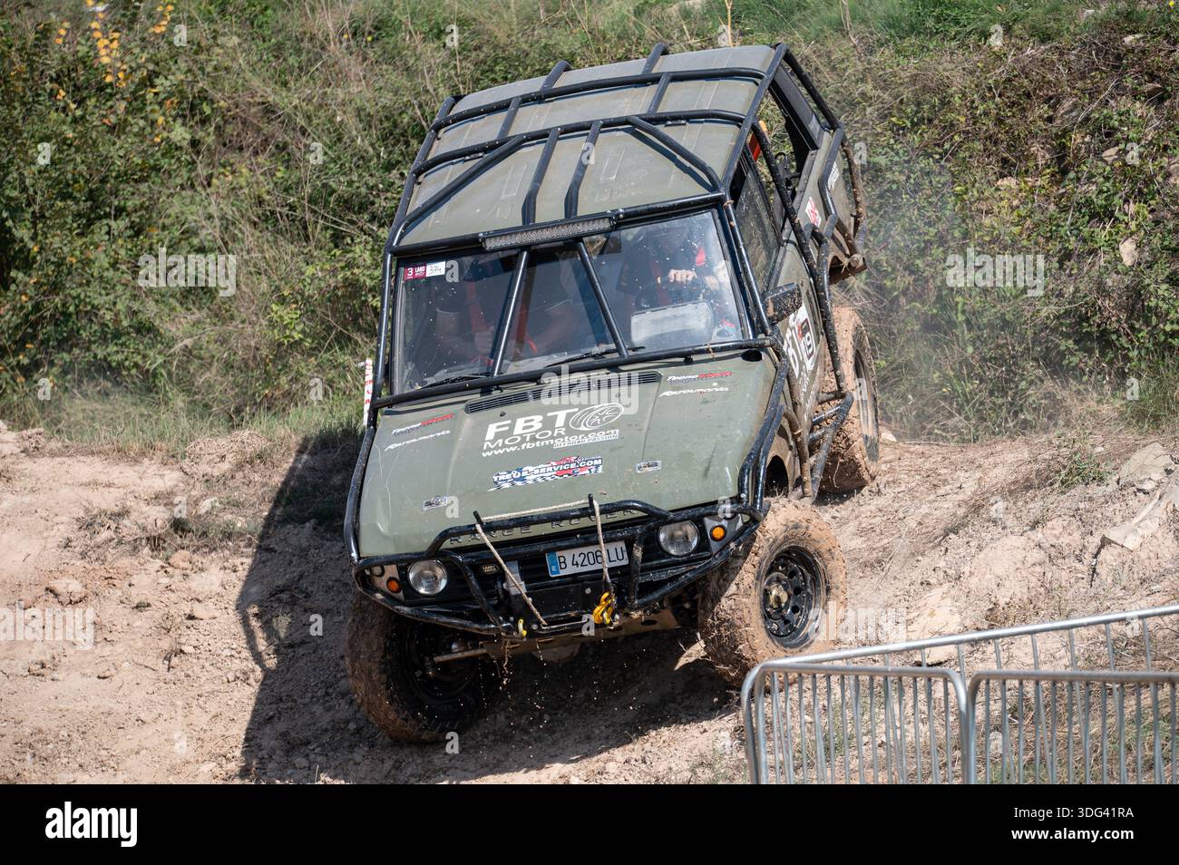 Front view of a modified green Range Rover Classic descending a steep ...