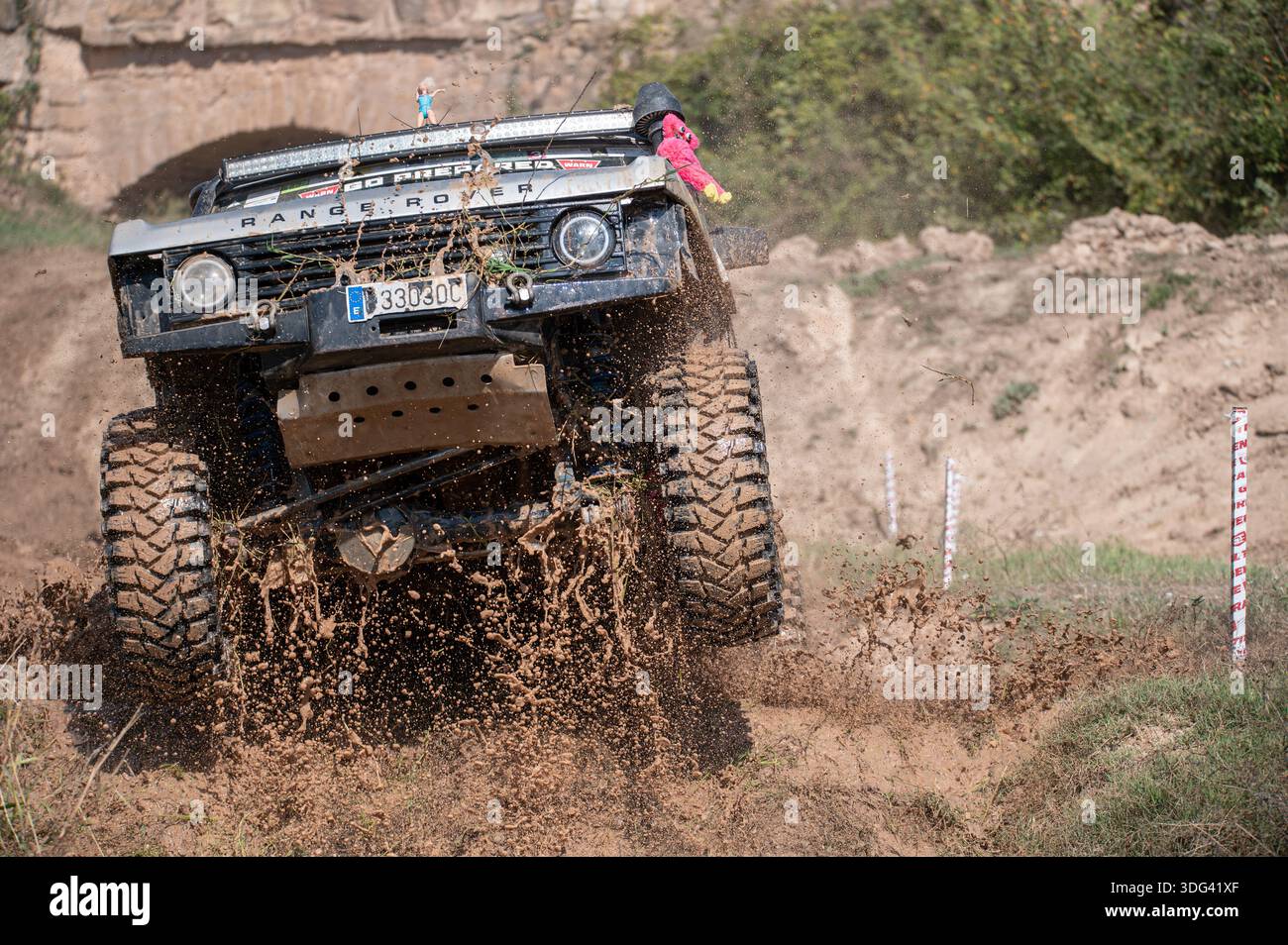 Front view of a silver modified Range Rover Classic jumping through ...