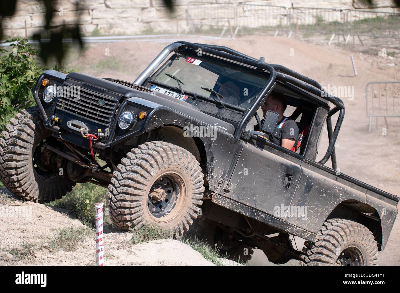 Front side view of a black modified Land Rover Defender pickup crawling ...