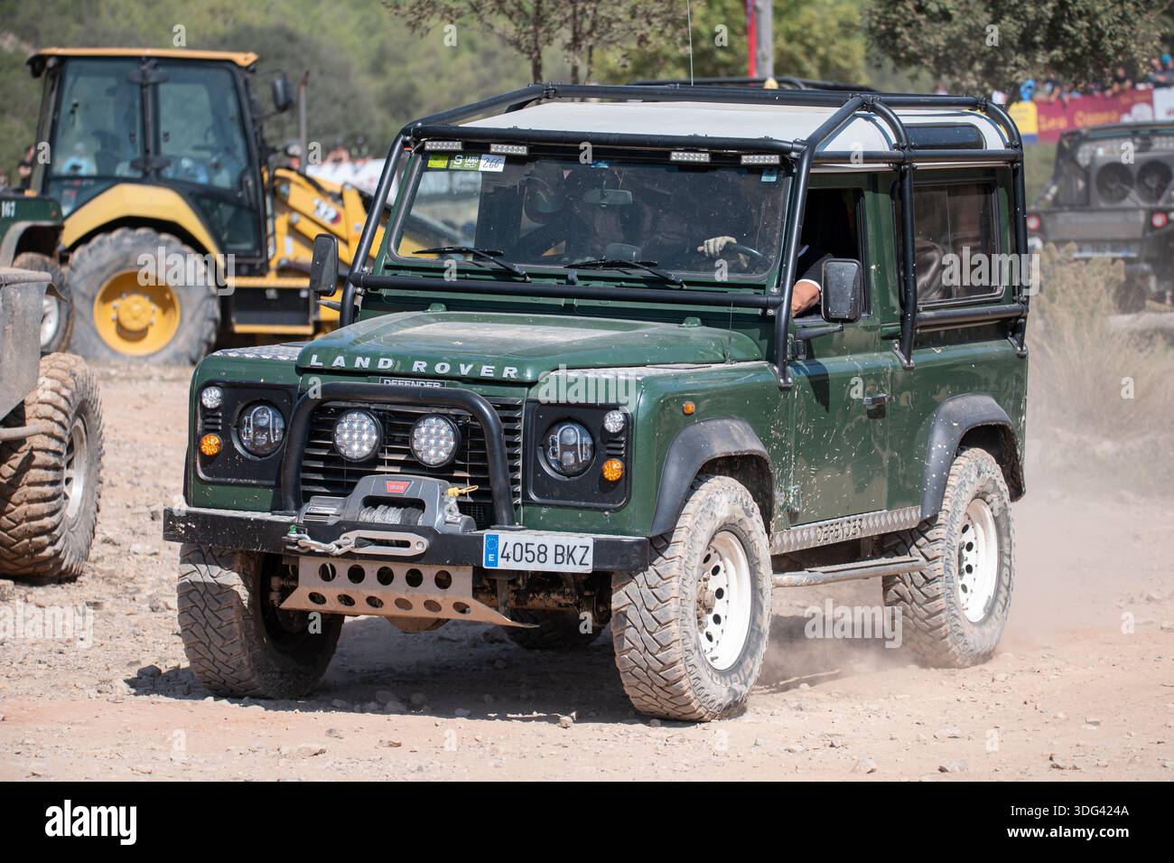Front view of a green modified Land Rover Defender 90 on a dirt path ...