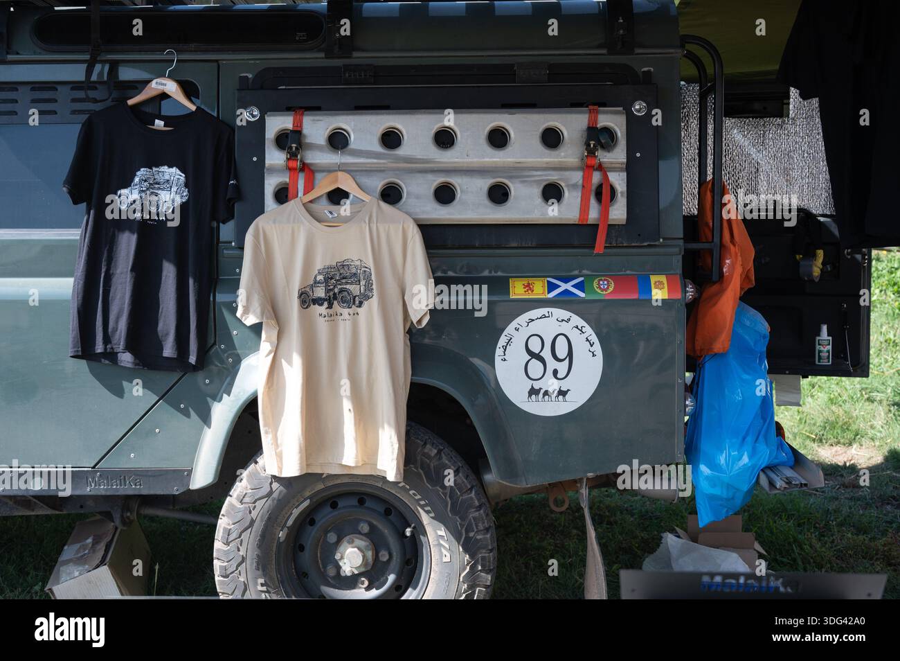 Side view of a Land Rover Defender used as a market stall. T-shirts and ...