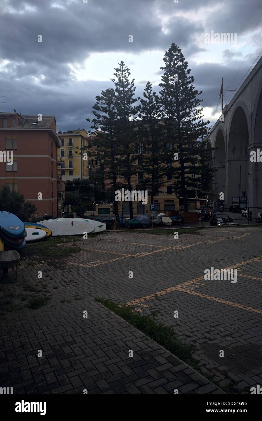 Square under the arches of a bridge with trees and covered boats in an ...