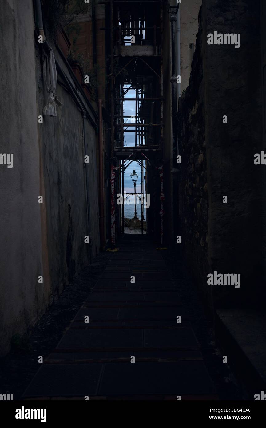 Narrow alley between tall buildings with a scaffolding hindering the ...