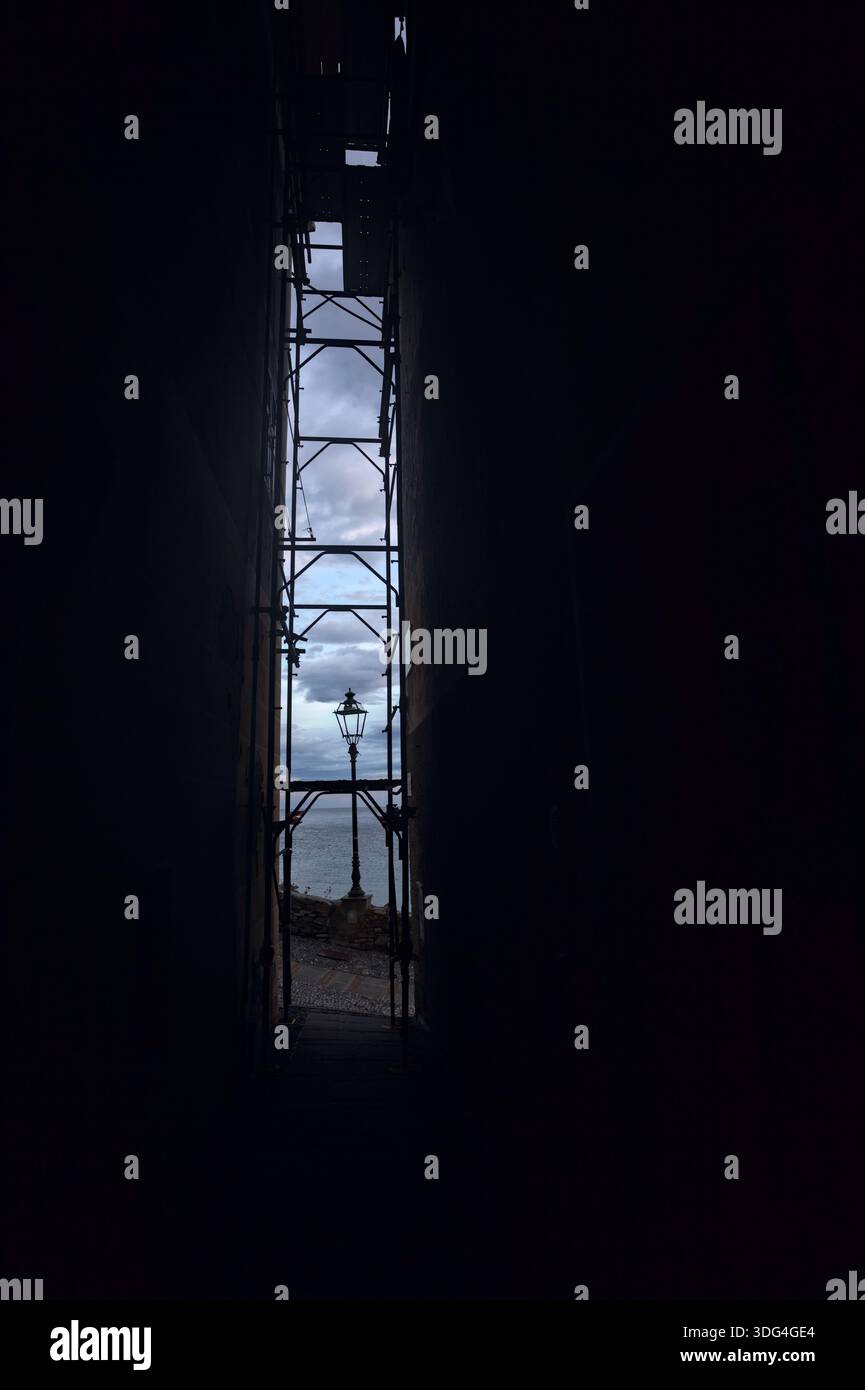 Narrow alley between tall buildings with a scaffolding hindering the ...