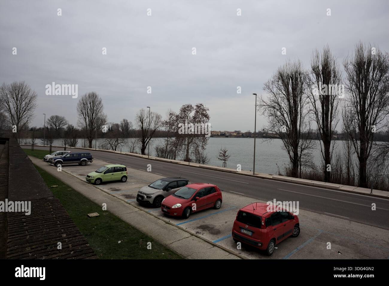 Mantova, Italy - 19TH FEBRUARY 2025 - Panoramic road with parked cars ...
