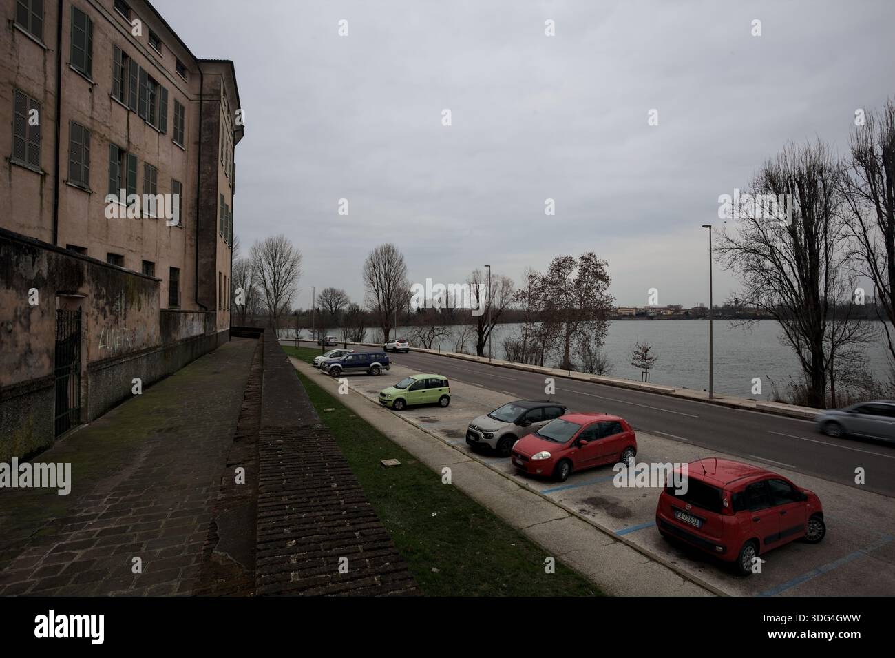Mantova, Italy - 19TH FEBRUARY 2025 - Panoramic road with parked cars ...