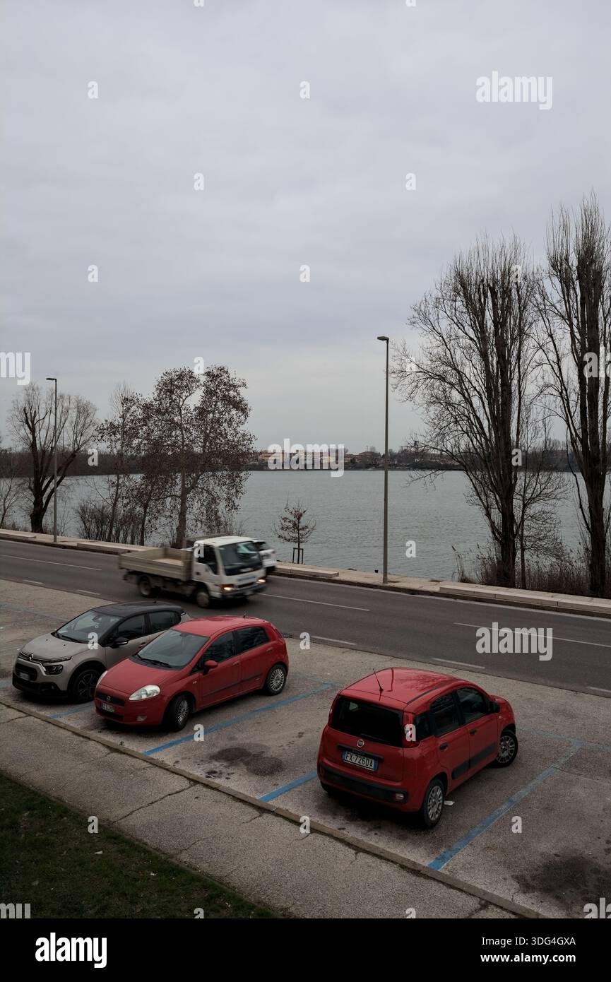Mantova, Italy - 19TH FEBRUARY 2025 - Panoramic road with parked cars ...