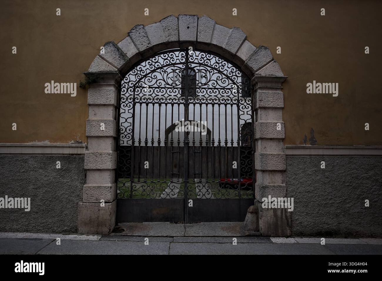 Closed iron gate in the facade of a palace with the inner yard behind ...