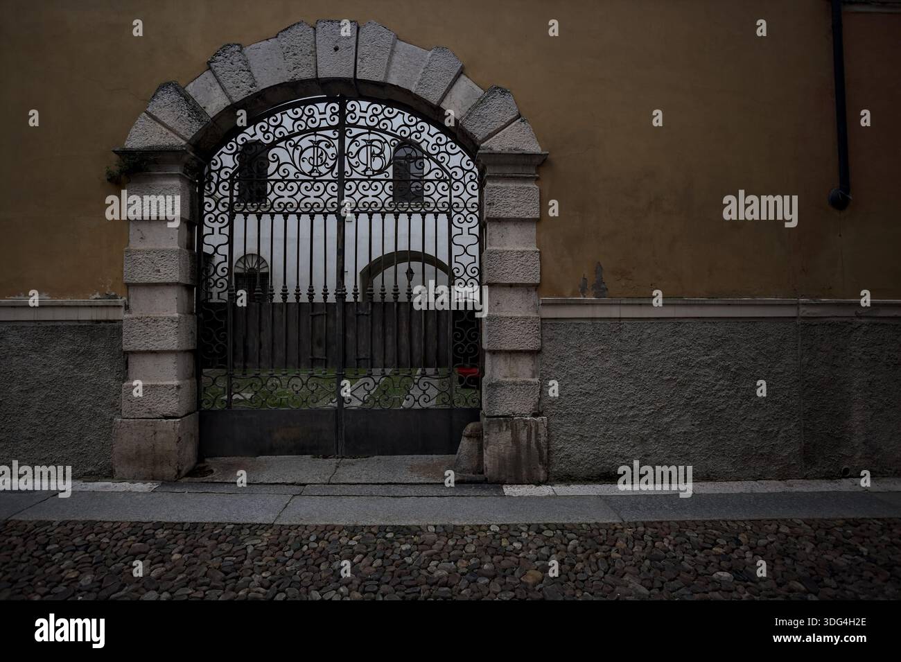 Closed iron gate in the facade of a palace with the inner yard behind ...