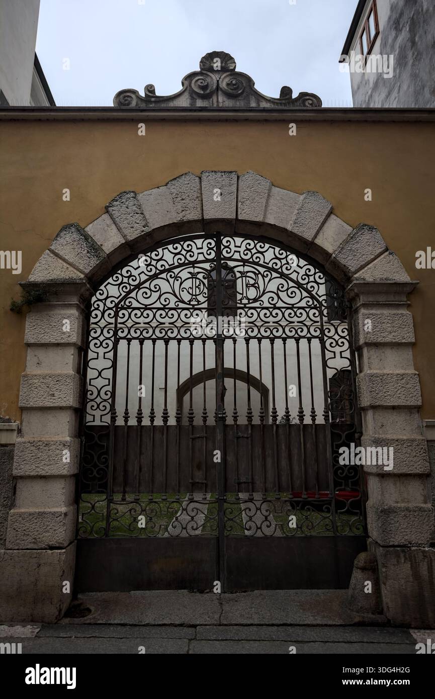 Closed iron gate in the facade of a palace with the inner yard behind ...