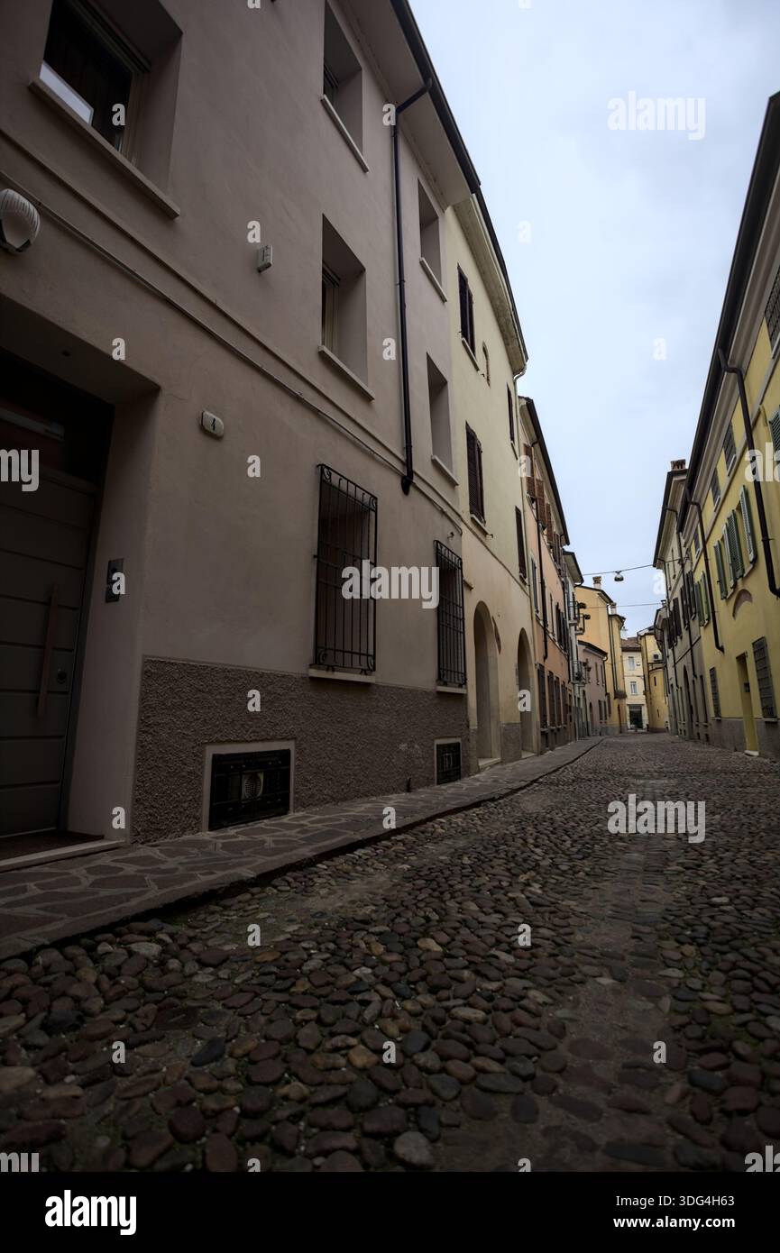 Cobbled alley that narrows at its end in an italian town on a cloudy ...