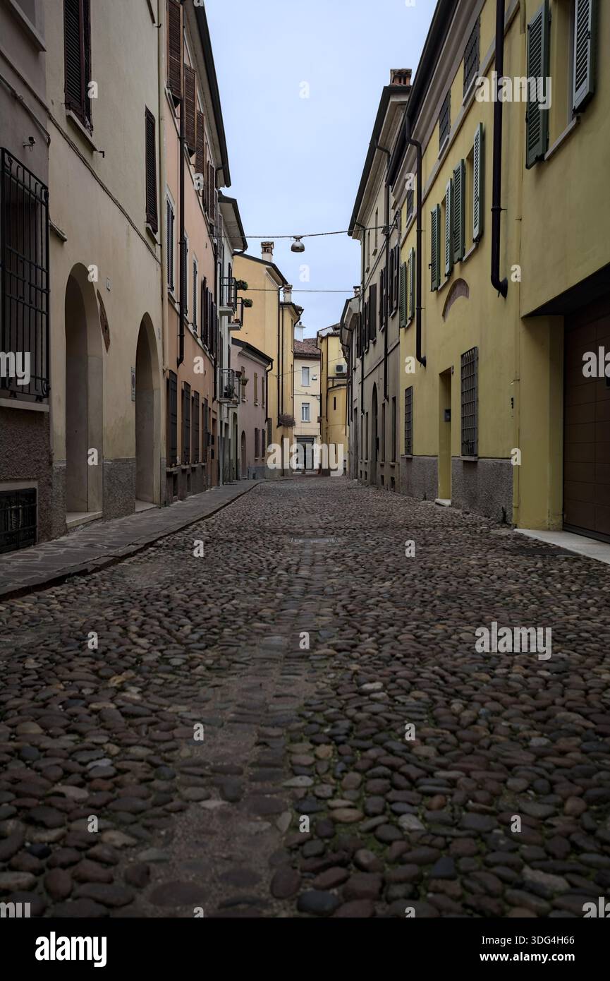 Cobbled alley that narrows at its end in an italian town on a cloudy ...