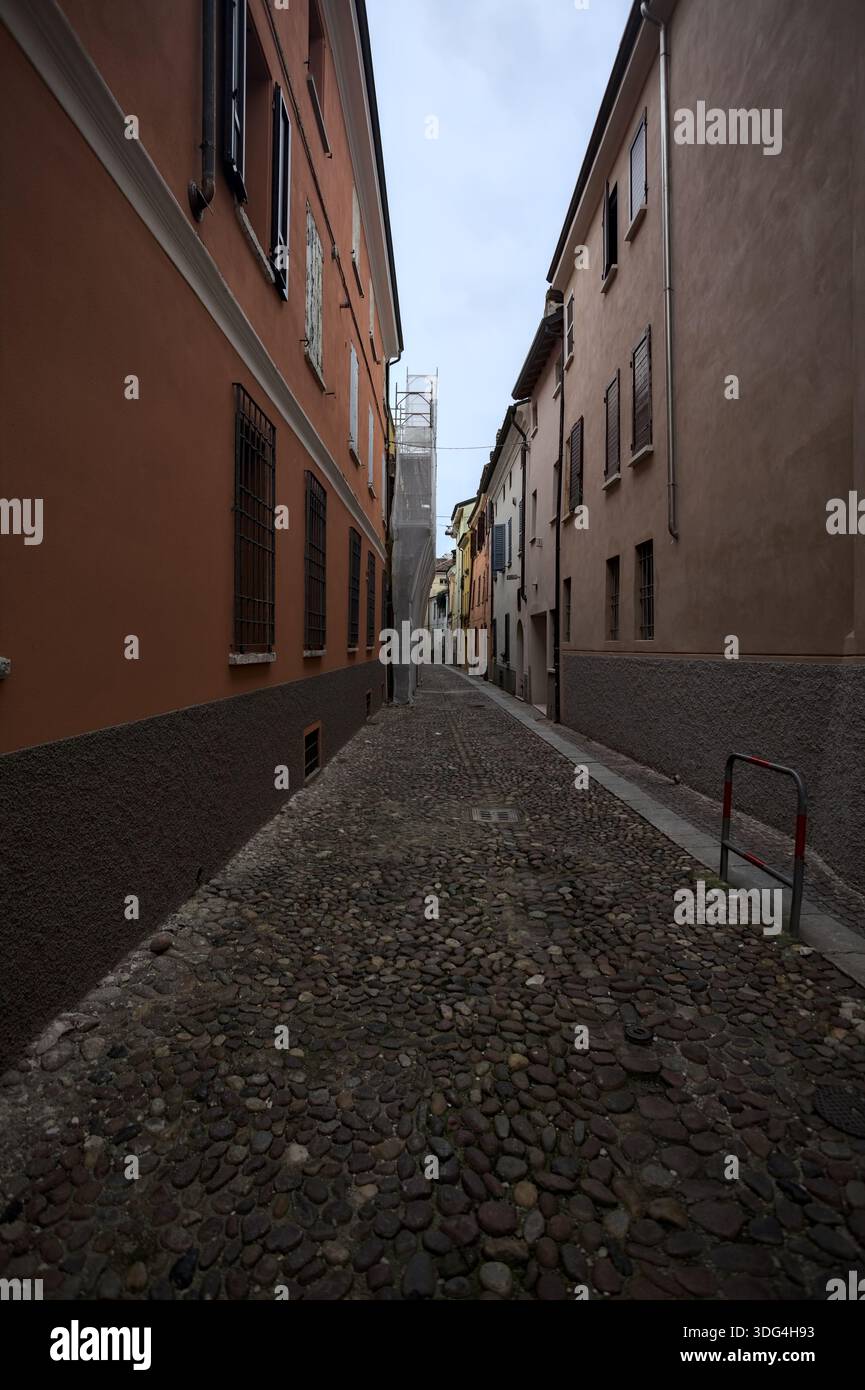 Cobbled alley partly in the shade with a scaffolding on a facade Stock ...