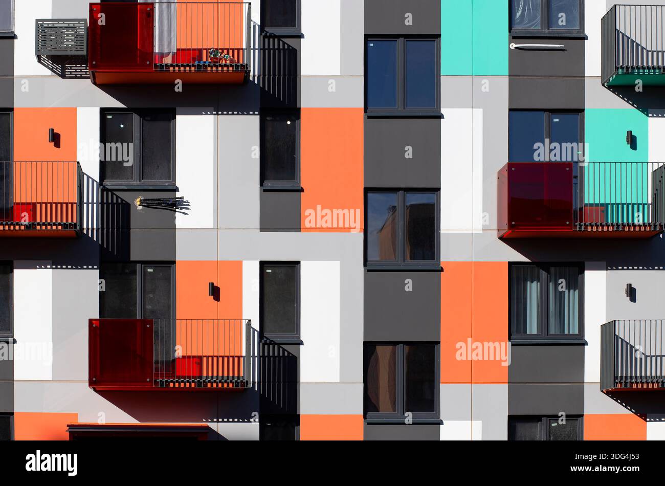 Modern apartment building facade with bold orange, gray, white, and ...