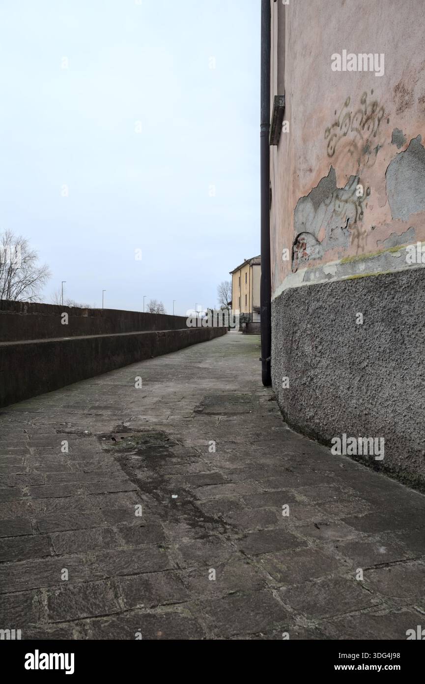 Passageway between a brick wall and the facade of a palace with a ...