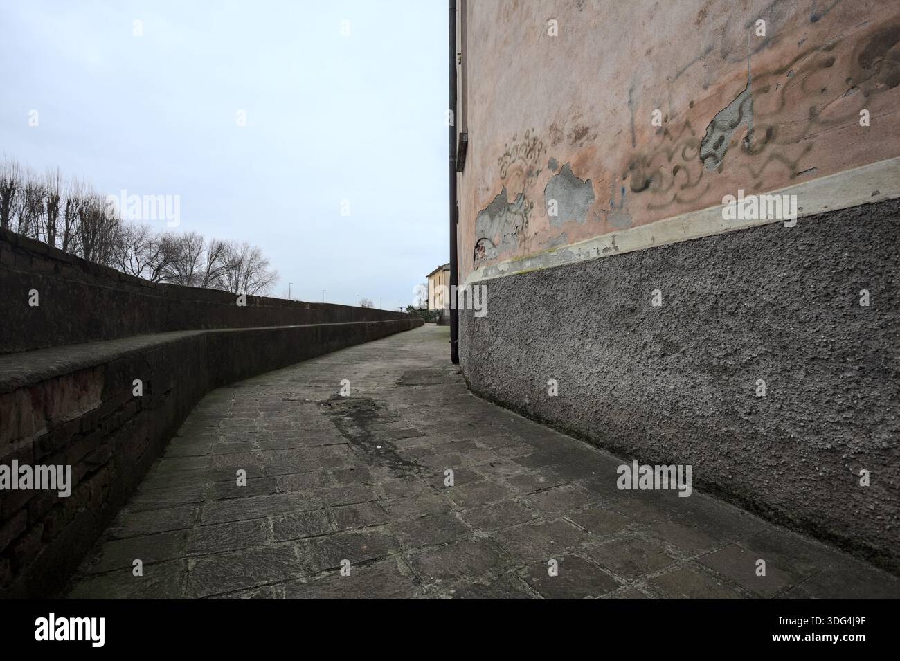 Passageway between a brick wall and the facade of a palace with a ...