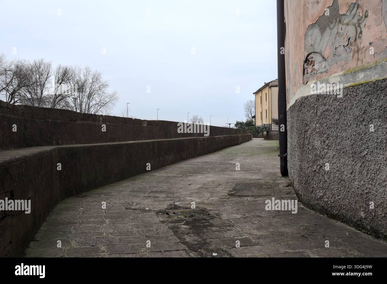 Passageway between a brick wall and the facade of a palace with a ...