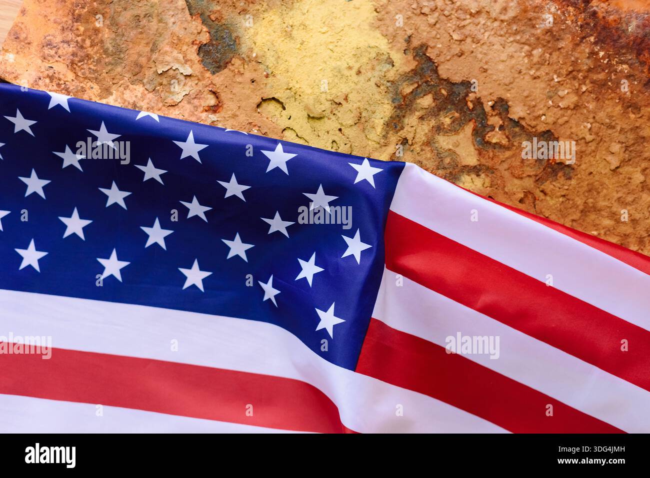 The American flag is placed on a rusty surface, showing the details of the flag and the texture ...