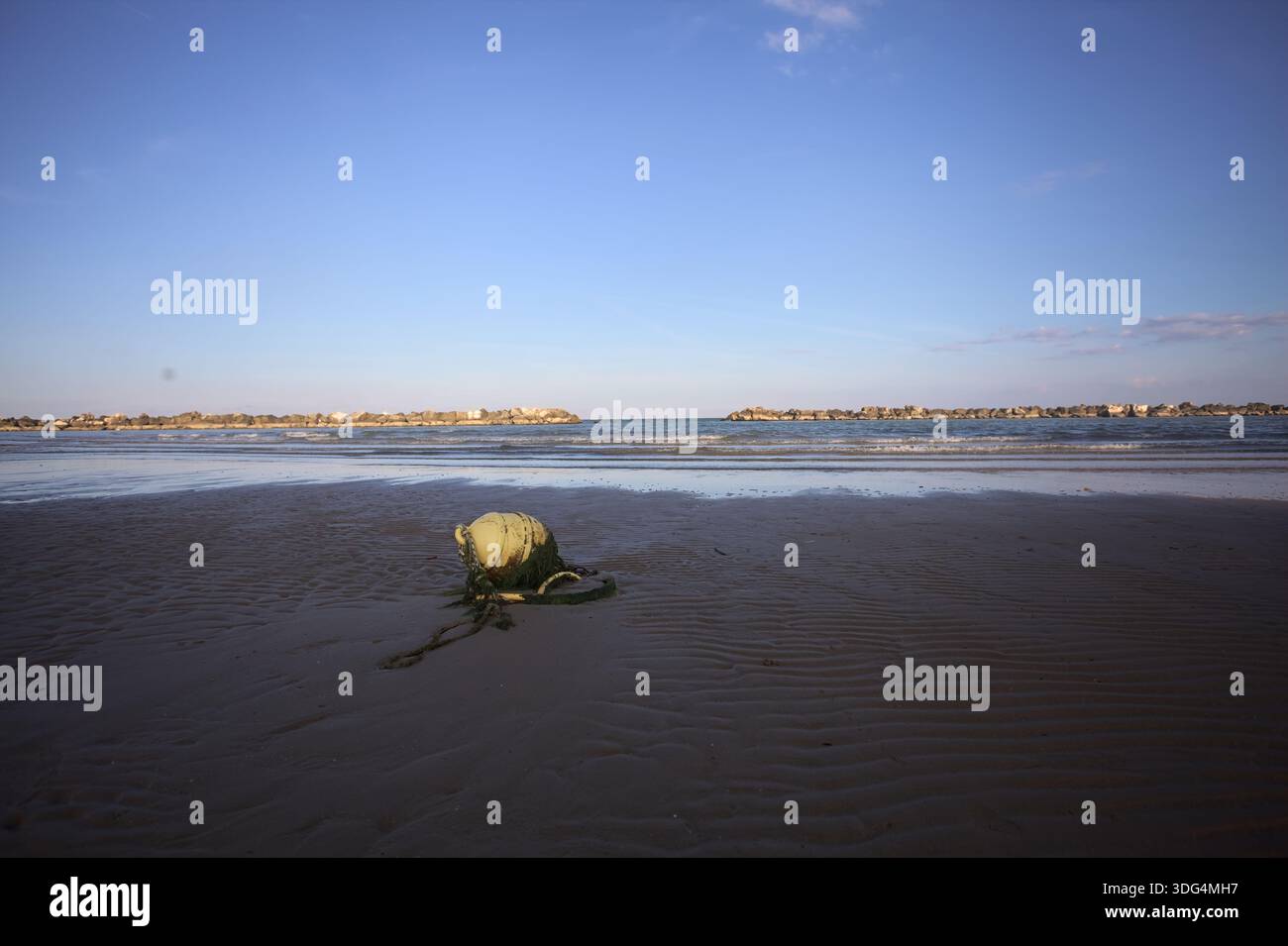 Buoy lying on the beach during a low tide at sunset Stock Photo - Alamy