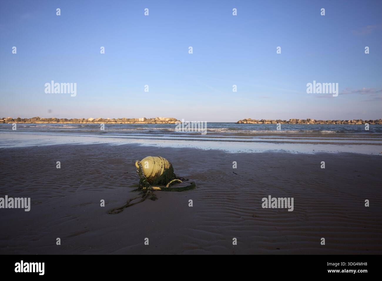 Buoy lying on the beach during a low tide at sunset Stock Photo - Alamy
